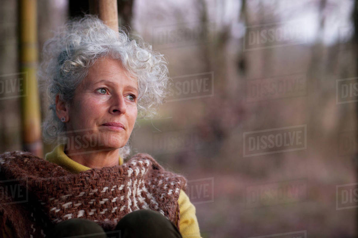 Portrait Of Grey Haired Mature Woman Gazing In Woodland At Dusk Stock