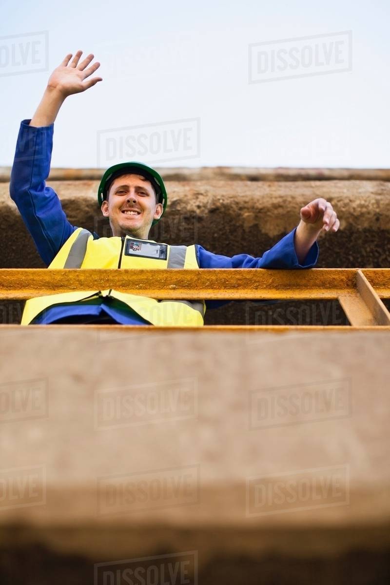 Worker waving from balcony - Stock Photo - Dissolve