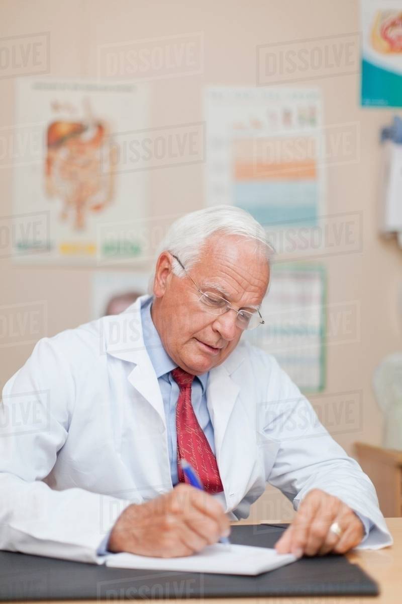 Doctor writing notes in office - Royalty-free Stock Photo | Dissolve