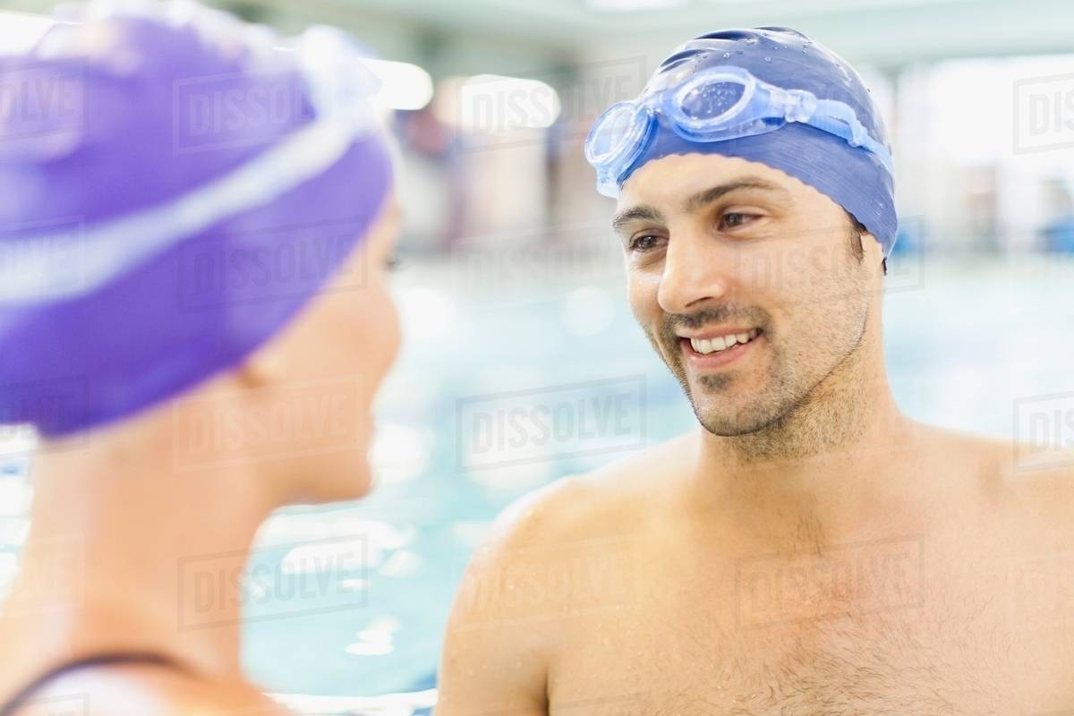 Swimmers talking by pool - Stock Photo - Dissolve