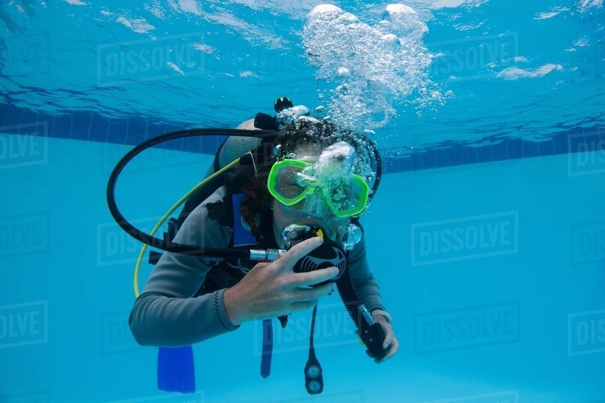 Woman practicing scuba diving in pool - Royalty-free Stock Photo | Dissolve
