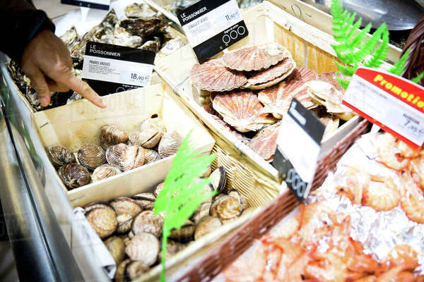 Hand pointing to shellfish display in supermarket, close-up - Royalty ...