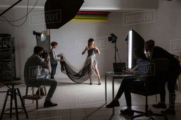 Photography team and model in low key photography studio shoot - Stock ...