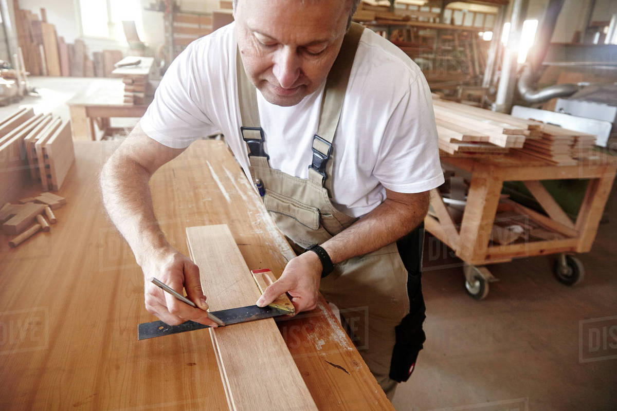Male carpenter using set square at workbench - Royalty-free Stock Photo ...