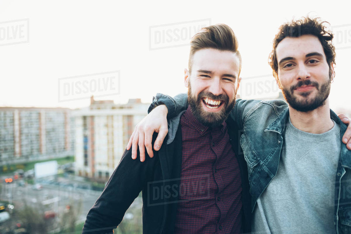 Portrait of two young men, on roof, smiling - Royalty-free Stock Photo ...