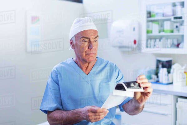 Doctor looking at medical scan - Stock Photo - Dissolve