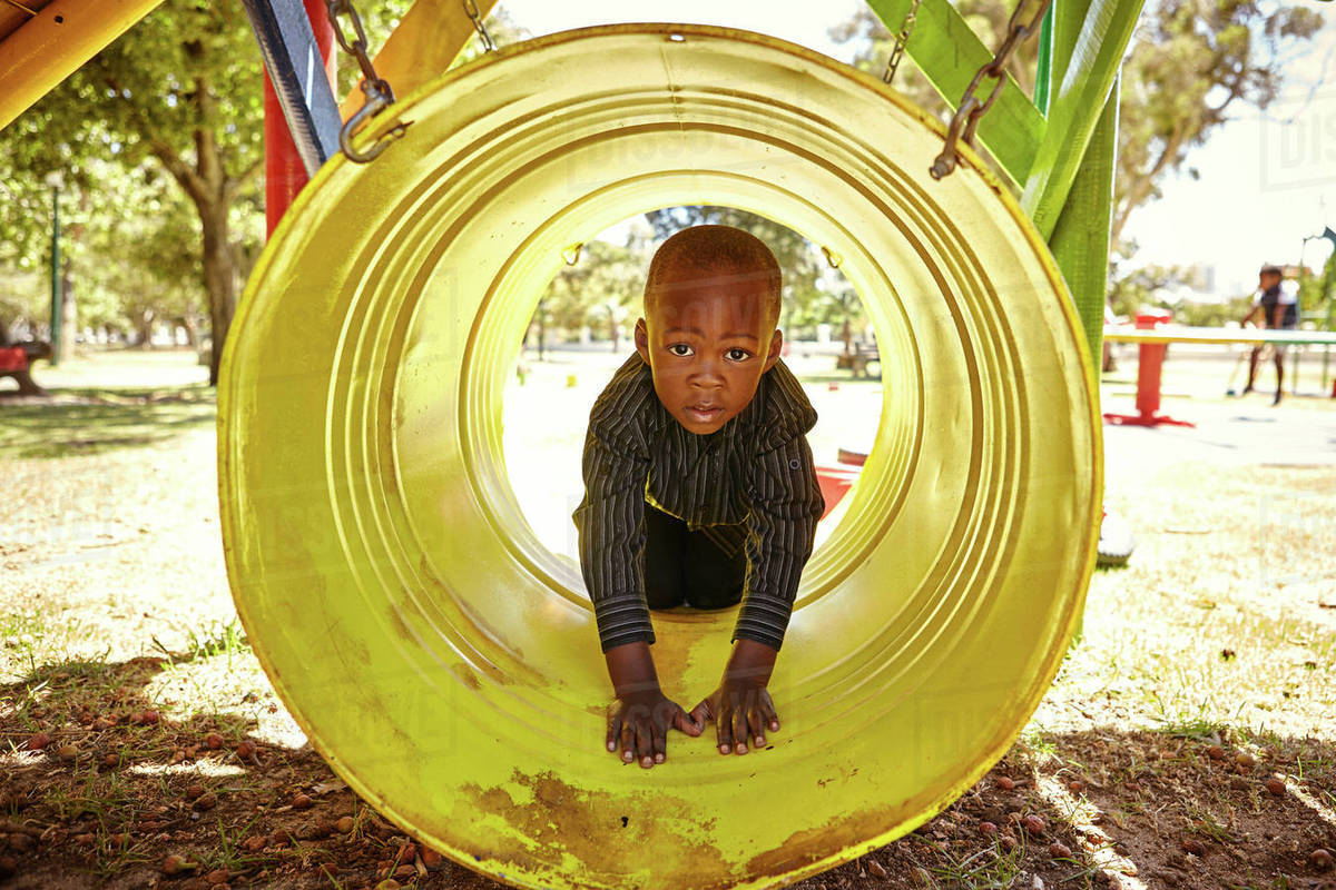 Boy in crawl tunnel in playground - Royalty-free Stock Photo | Dissolve