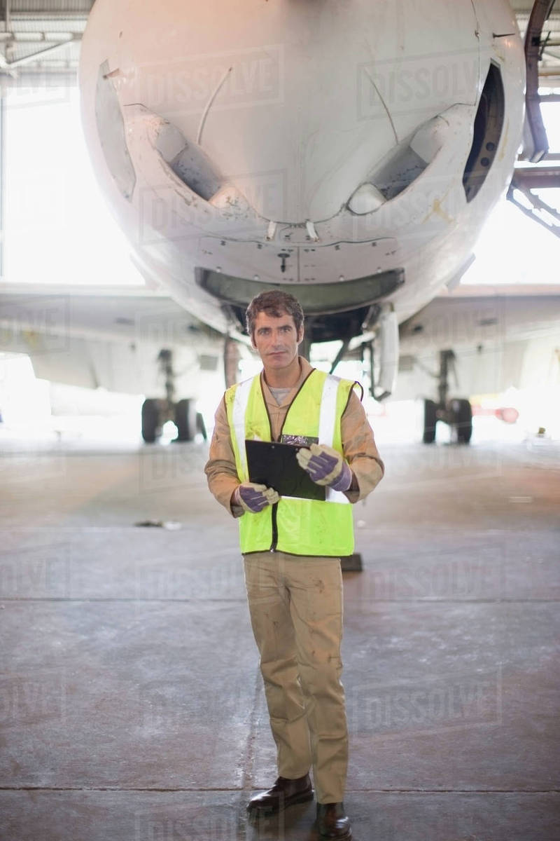 Aircraft worker standing on airfield - Royalty-free Stock Photo | Dissolve