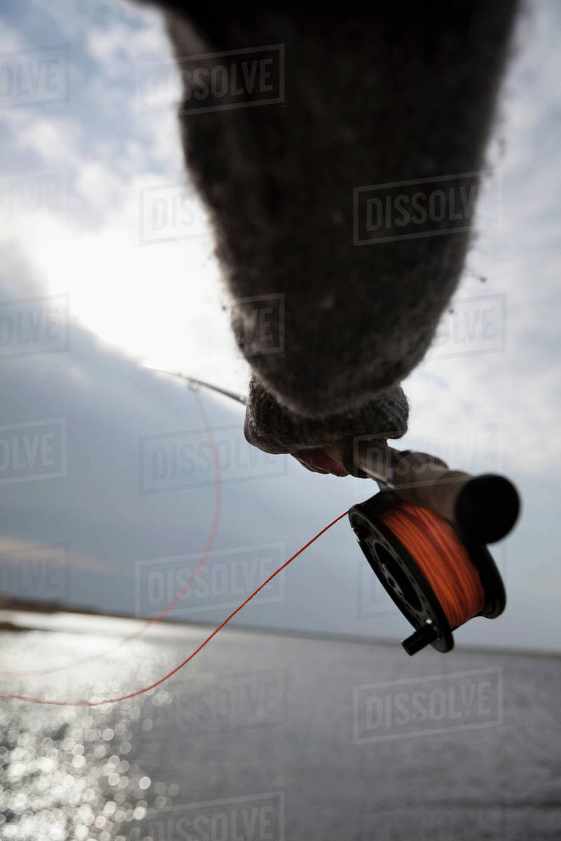 Close up of man using fishing rod - Stock Photo - Dissolve