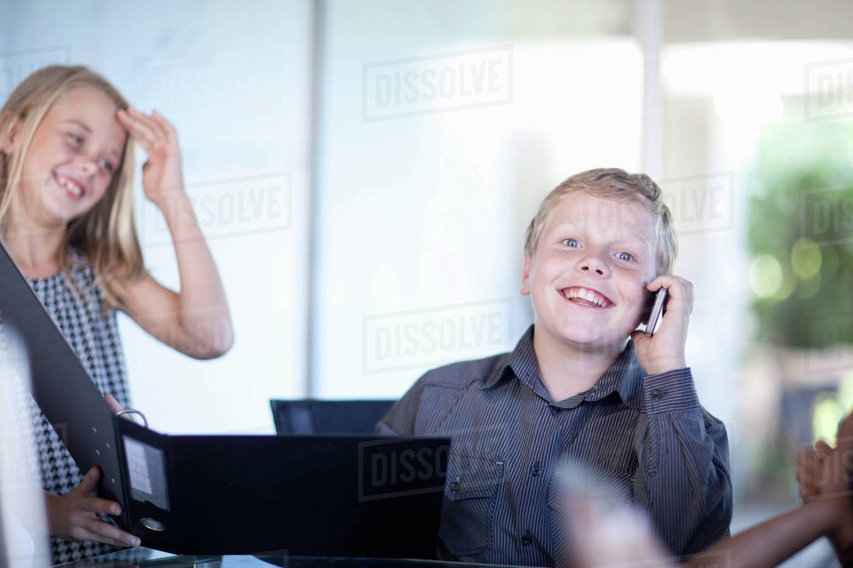 Children playing business people at desk - Stock Photo - Dissolve