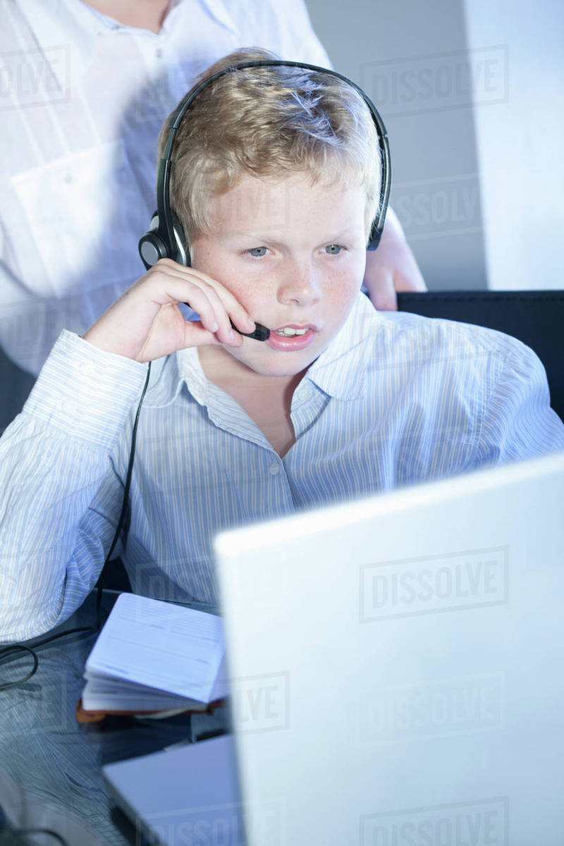 Boy playing businessman at desk - Royalty-free Stock Photo | Dissolve