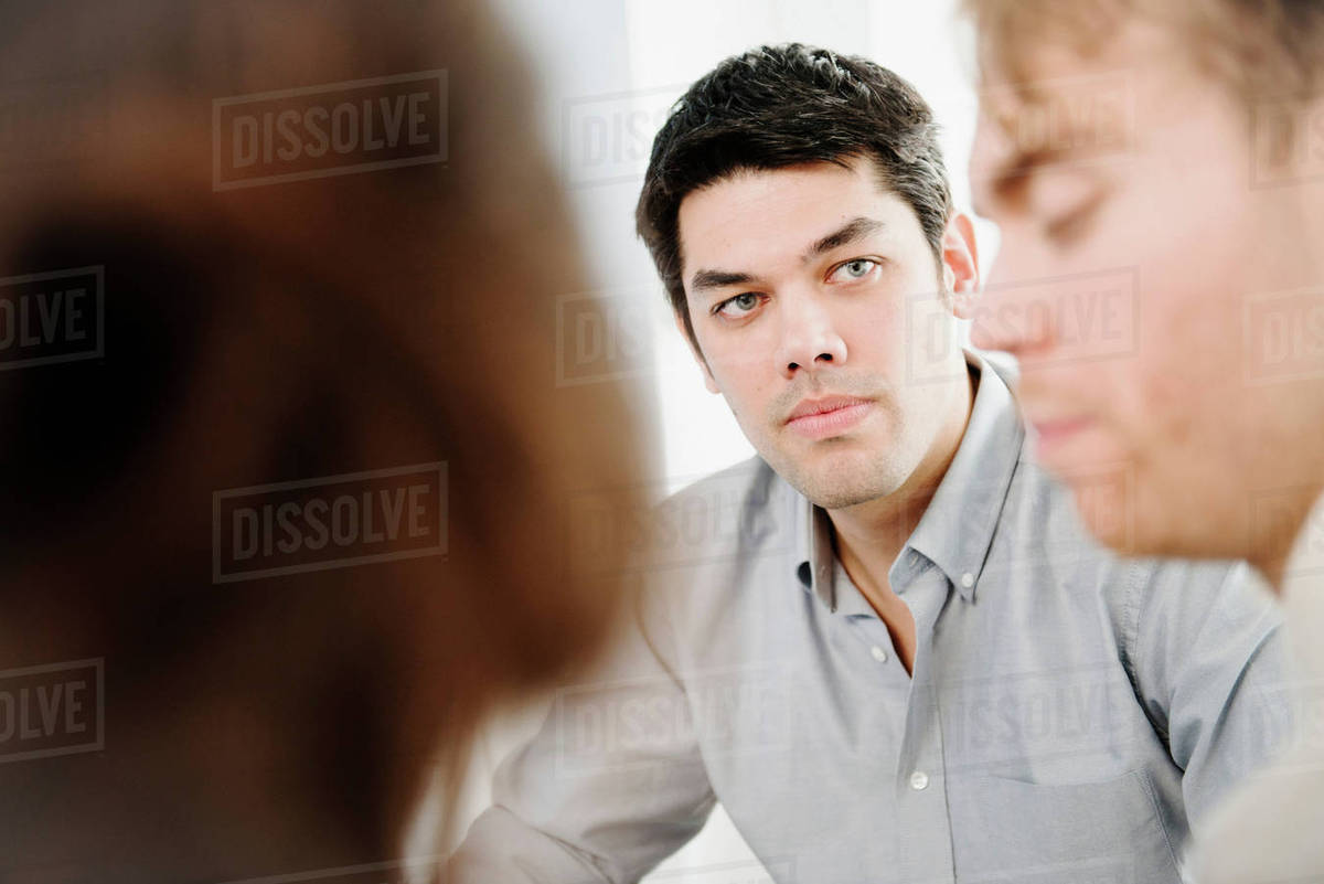 Man wearing shirt looking at male colleague - Stock Photo - Dissolve
