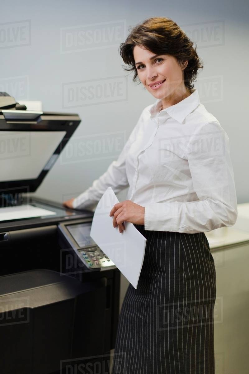 Businesswoman making copies in office - Royalty-free Stock Photo | Dissolve