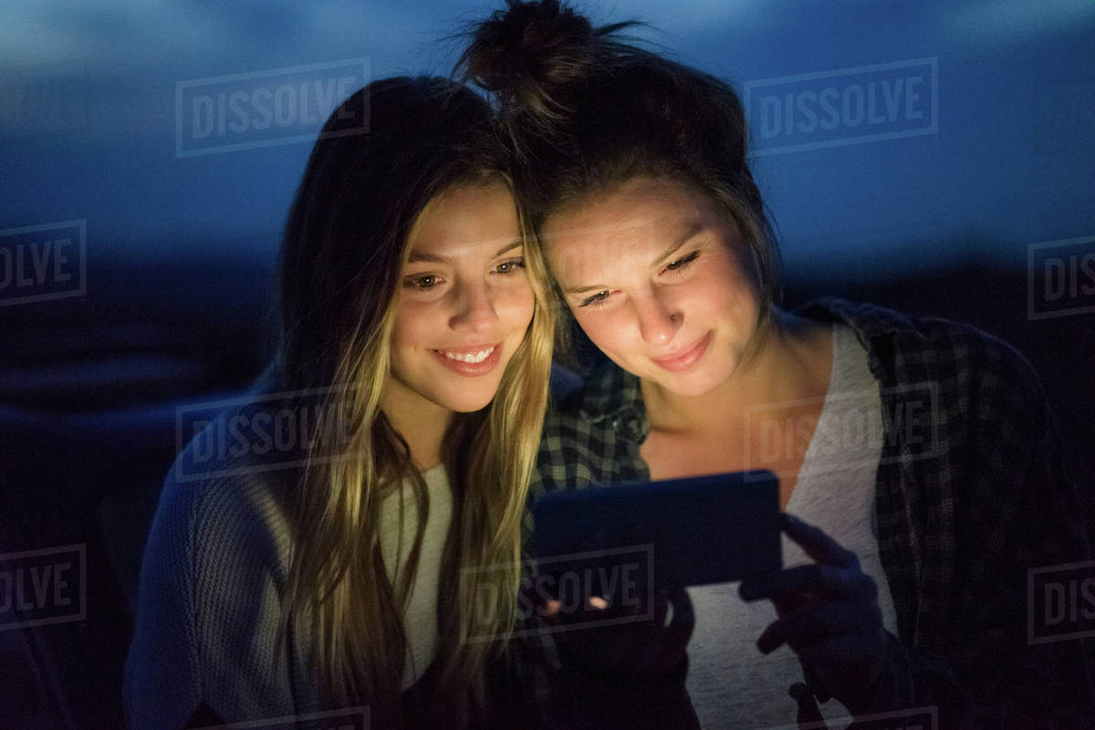 Friends using mobile phone - Royalty-free Stock Photo | Dissolve