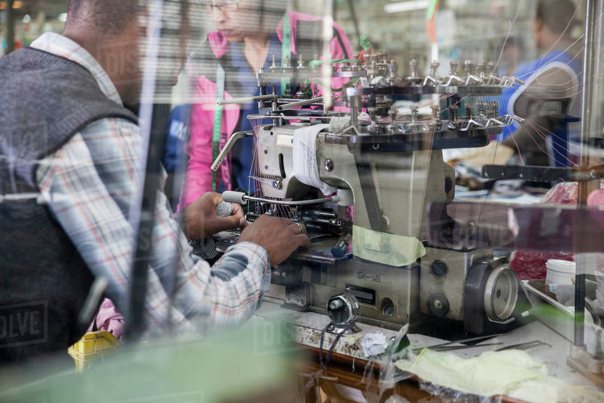 Maintenance man working on industrial smocking sewing machine, Cape ...