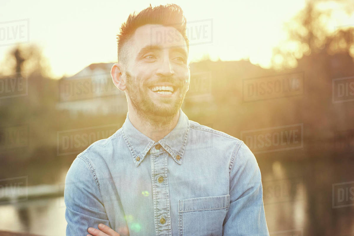 Hazy lens flare shot of bearded young man by River Thames, Richmond, UK ...