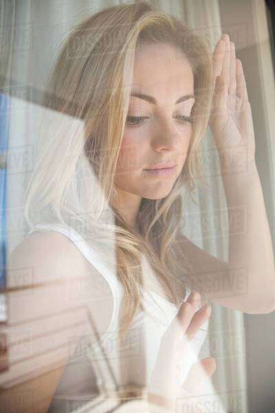 Woman gazing out window - Stock Photo - Dissolve