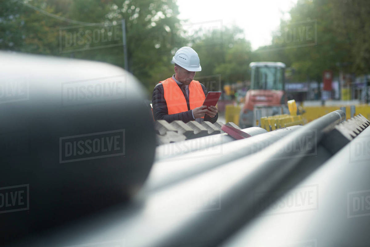 Road engineer standing by pipes - Royalty-free Stock Photo | Dissolve