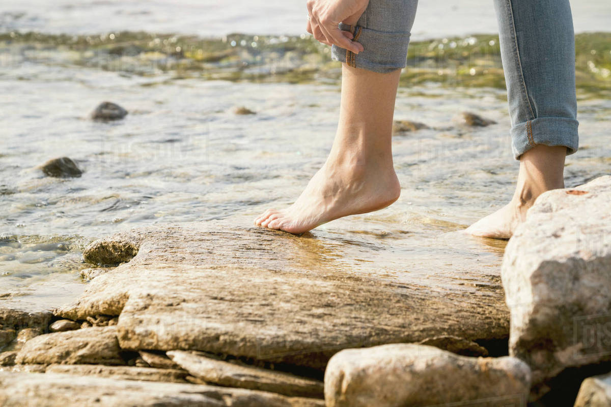 Cropped view of woman barefoot on rocks - Royalty-free Stock Photo ...