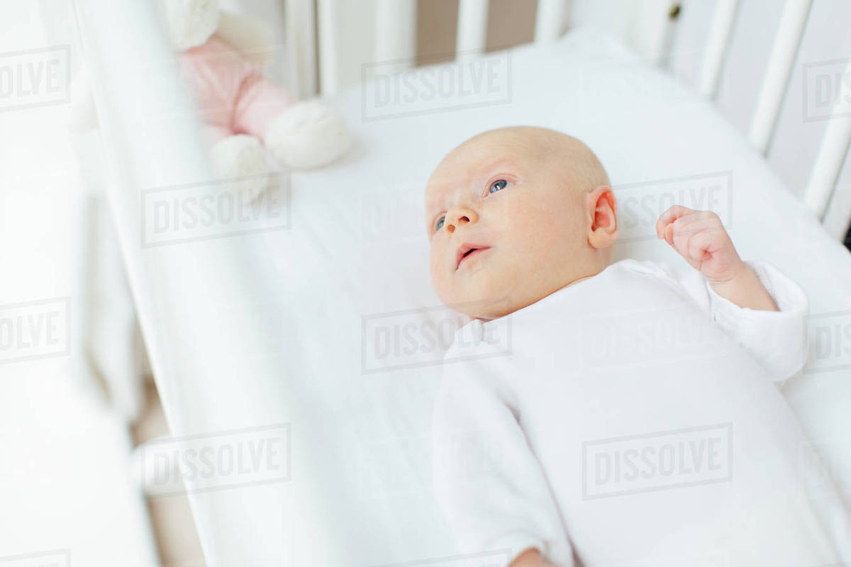 Overhead view of baby girl lying in crib - Royalty-free Stock Photo ...