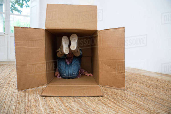 Boy lying in cardboard box with legs raised - Royalty-free Stock Photo ...