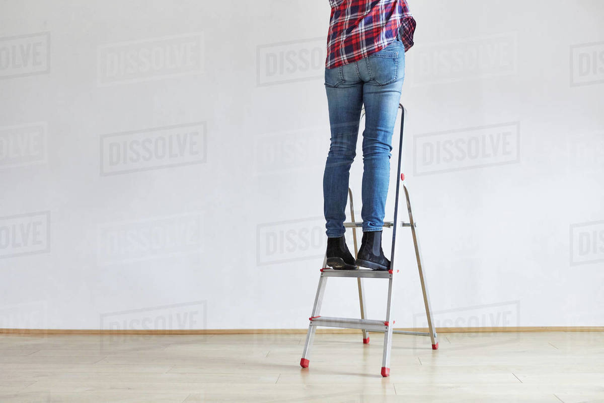 Person standing on ladder - Royalty-free Stock Photo | Dissolve