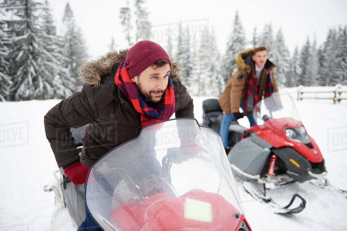 Young men riding snowmobiles in winter - Stock Photo - Dissolve