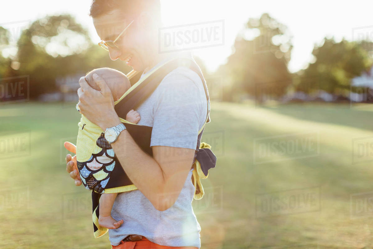 Father carrying baby boy in baby carrier - Stock Photo - Dissolve
