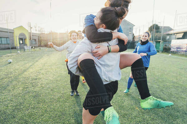 Football players jubilant and hugging on pitch - Royalty-free Stock ...