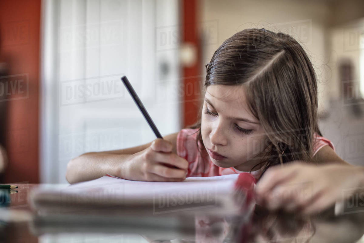 Girl writing at table - Stock Photo - Dissolve