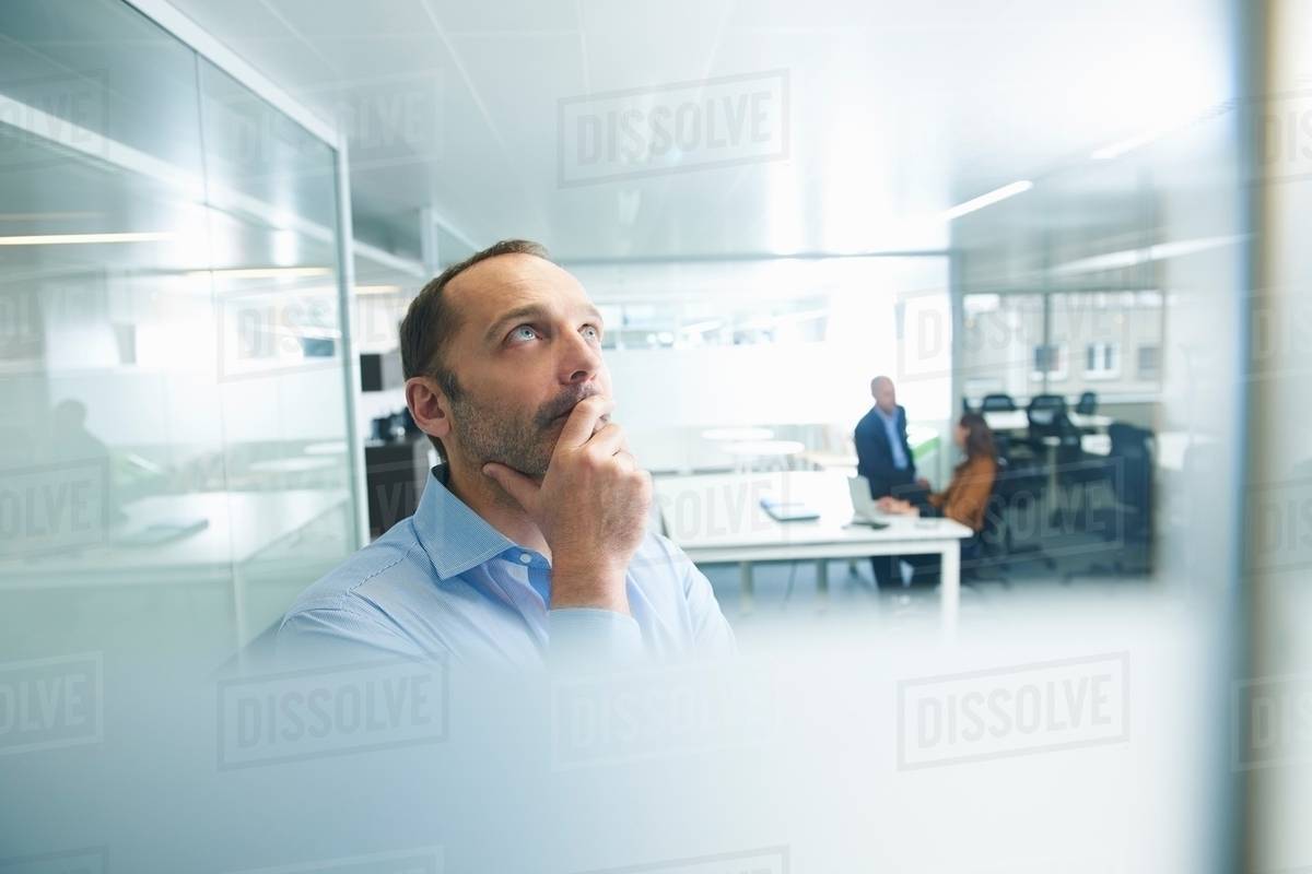 Man thinking, people in background - Stock Photo - Dissolve