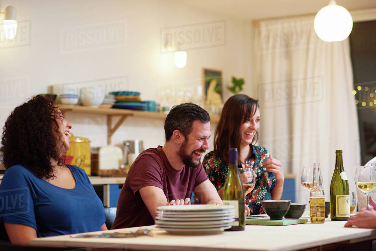 Friends laughing at dinner party - Stock Photo - Dissolve