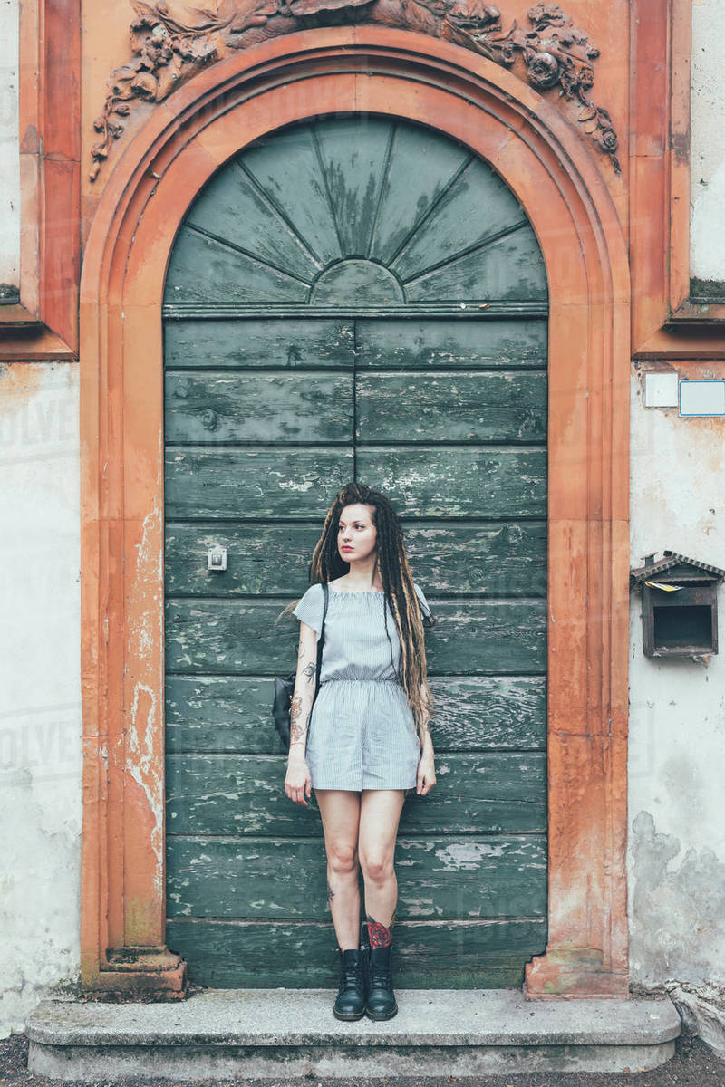 Woman leaning against arched door - Royalty-free Stock Photo | Dissolve