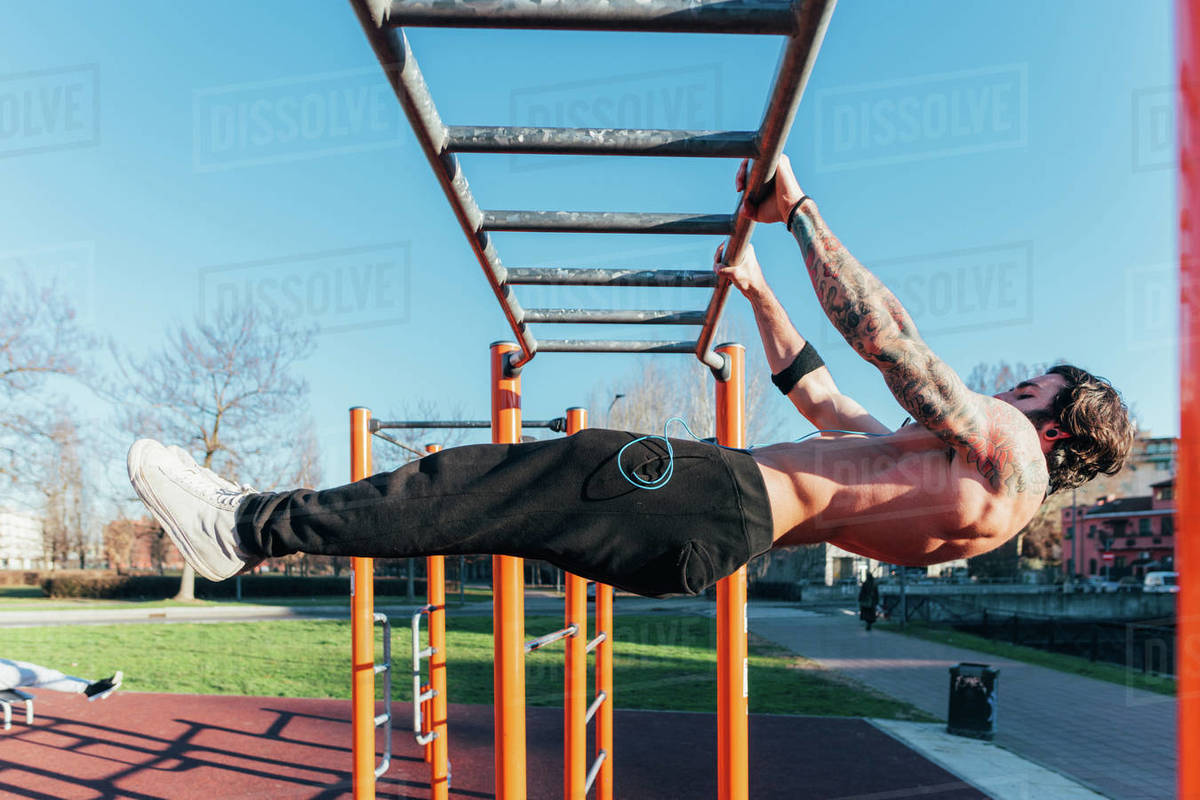 Man using horizontal ladder in outdoor gym - Royalty-free Stock Photo ...