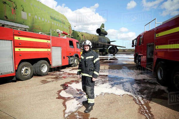 Fire training, fireman by fire engines at training facility, portrait ...