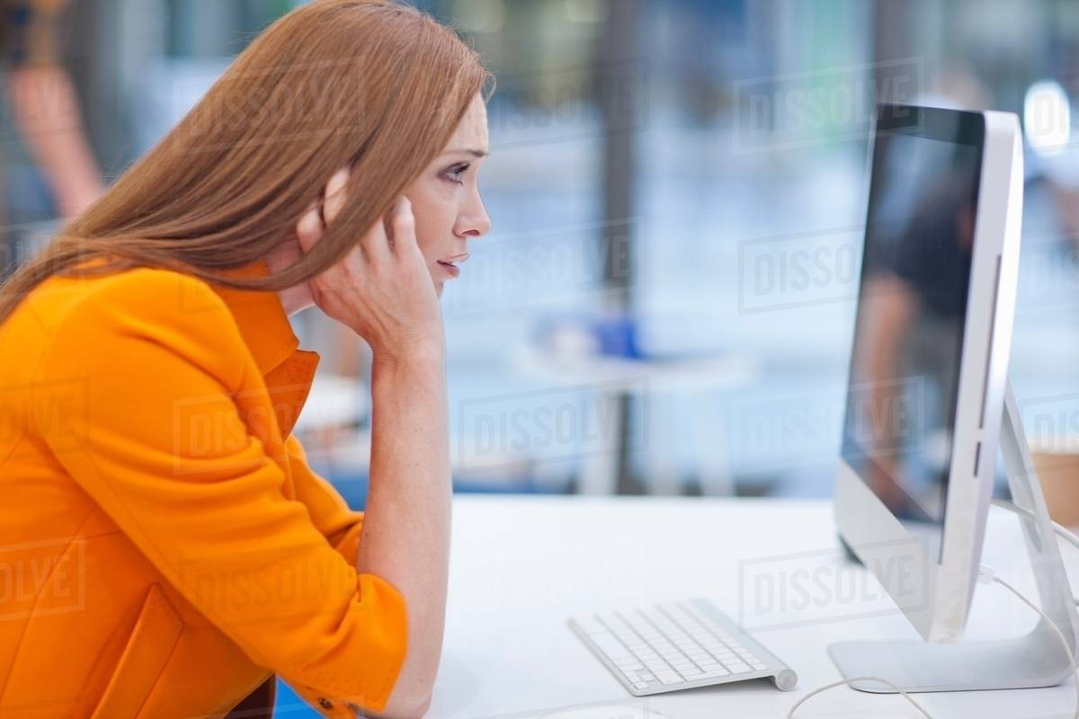 Female office worker staring at computer screen - Stock Photo - Dissolve