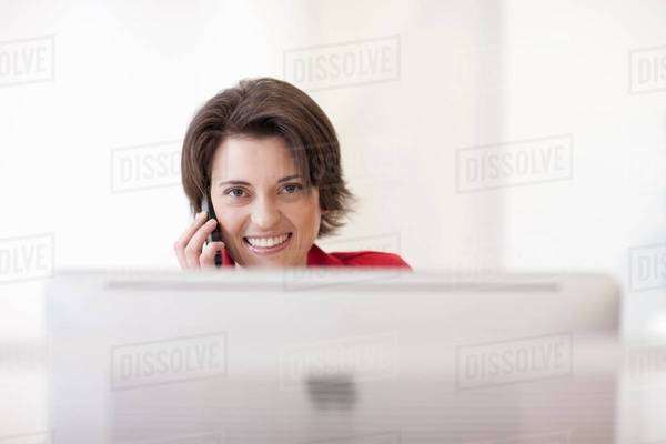Female office worker on cell phone - Stock Photo - Dissolve