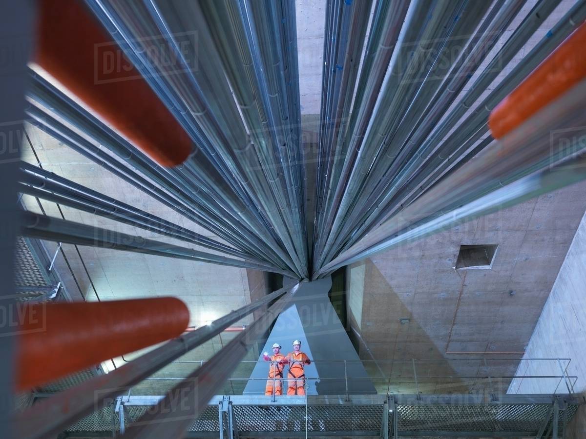 Civil engineers inspecting cable anchorage in suspension bridge, low angle view. The Humber ...