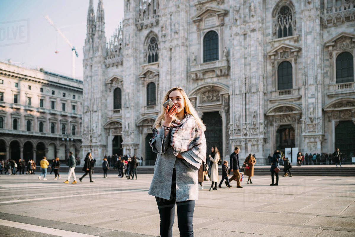Young female tourist talking at smartphone by Milan Cathedral, Milan ...