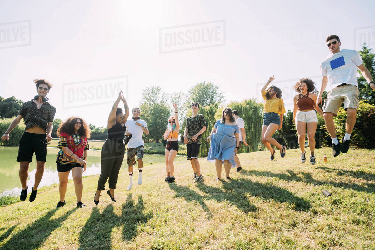 Group of friends jumping in park - Royalty-free Stock Photo | Dissolve