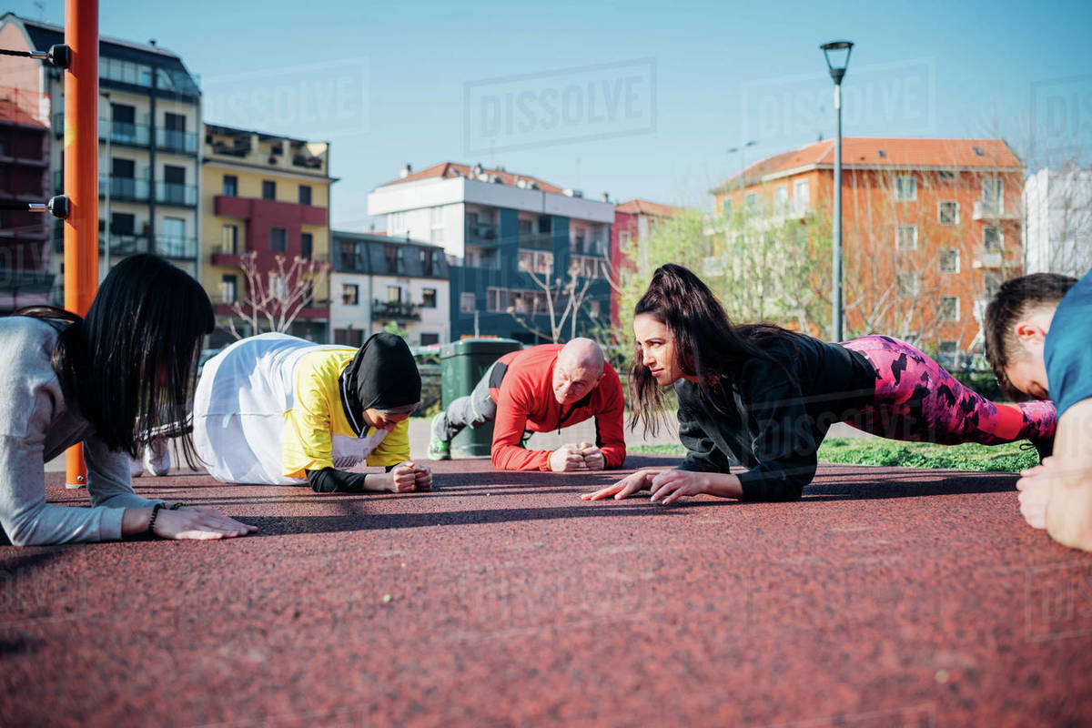 Calisthenics class in park, males and females doing push ups - Stock ...