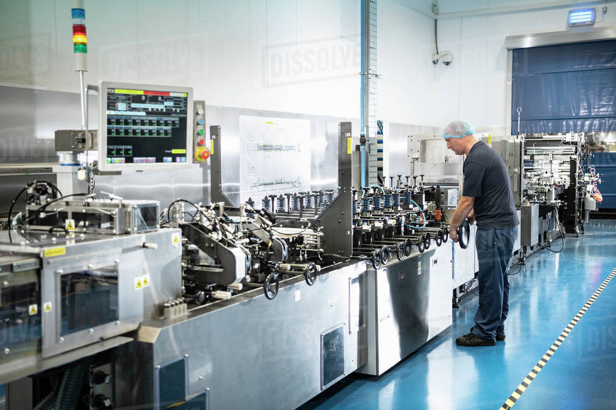 Worker with food packaging printing machine in print factory - Stock ...