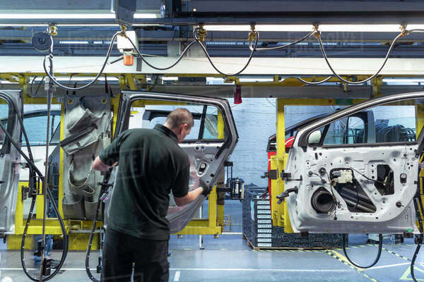 Worker on car door assembly line in car factory - Stock Photo - Dissolve