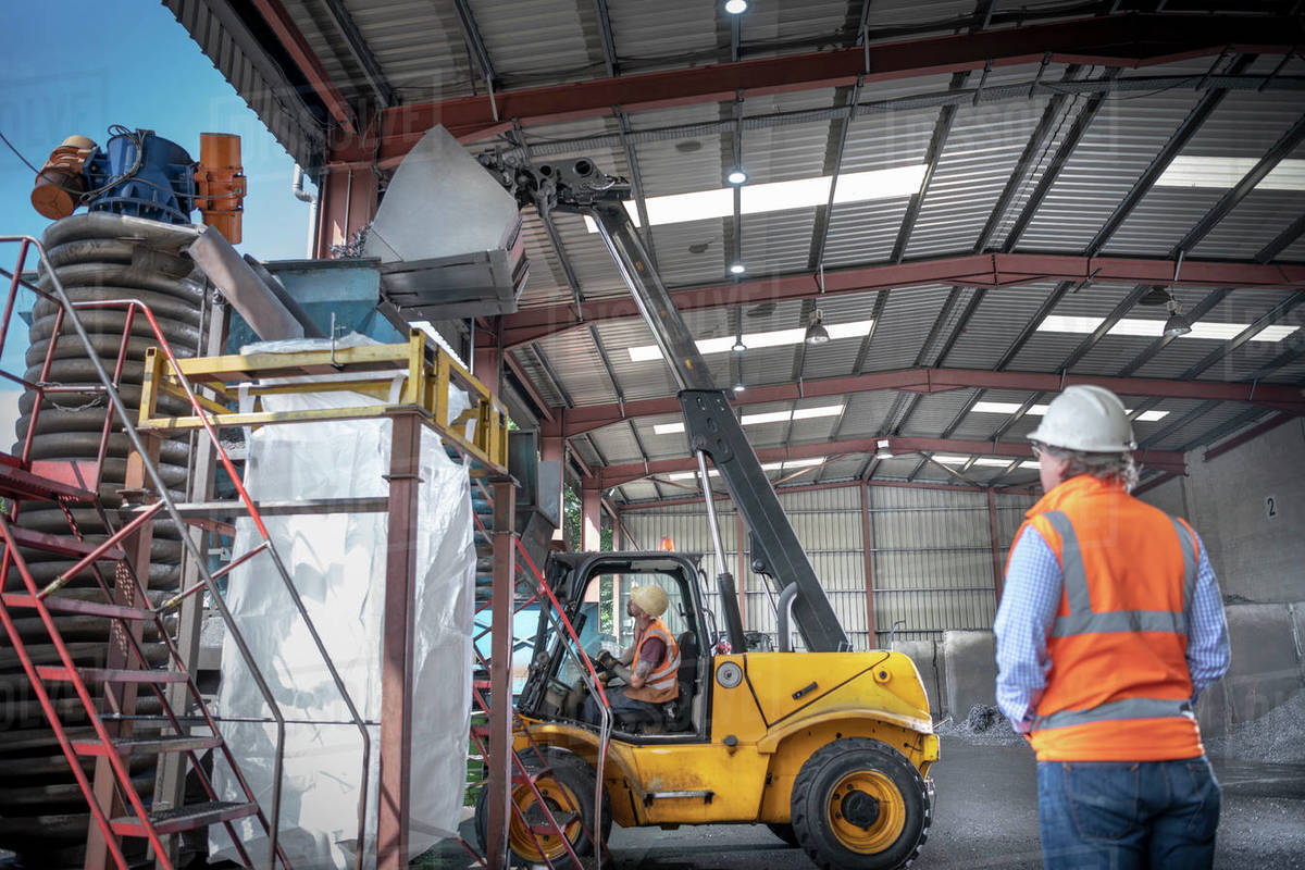 Titanium scrap being tipped into sorting machine in titanium recycling ...
