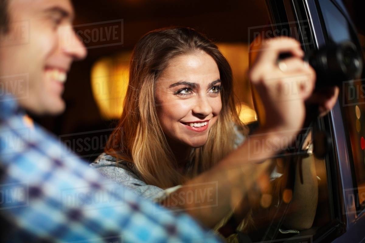 Couple photographing out of city taxi window at night - Stock Photo ...