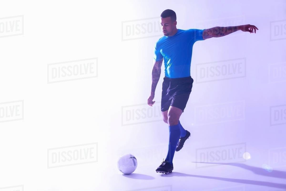 Studio shot of young male soccer player kicking the ball - Stock Photo ...