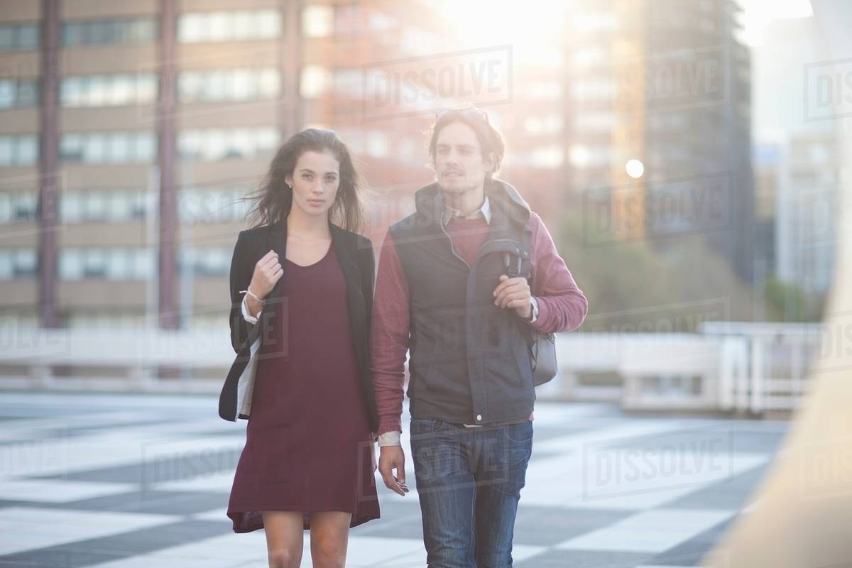 Couple walking across rooftop parking lot in city - Royalty-free Stock ...