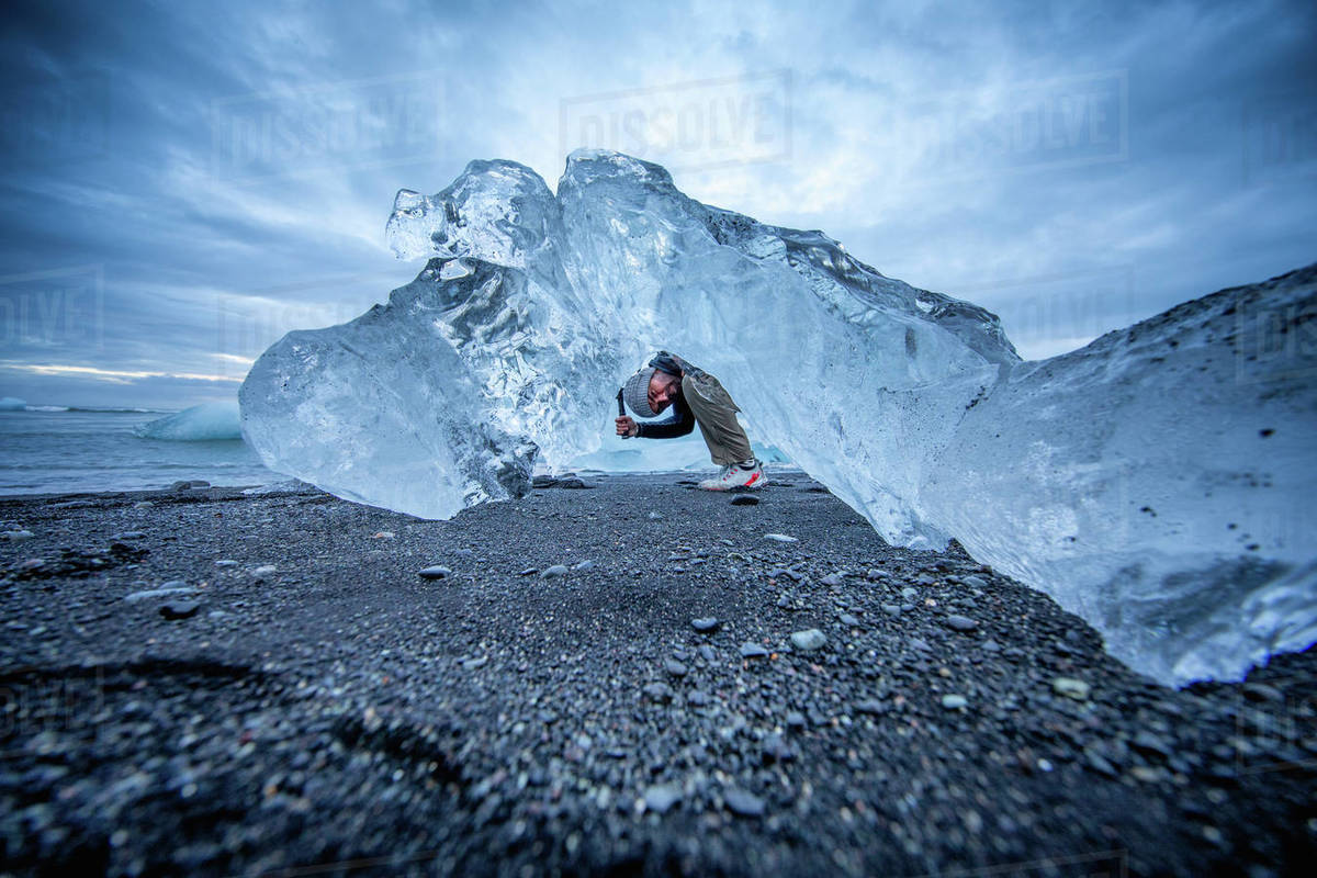 Man exploring ice formations, Diamond beach, Iceland - Royalty-free ...