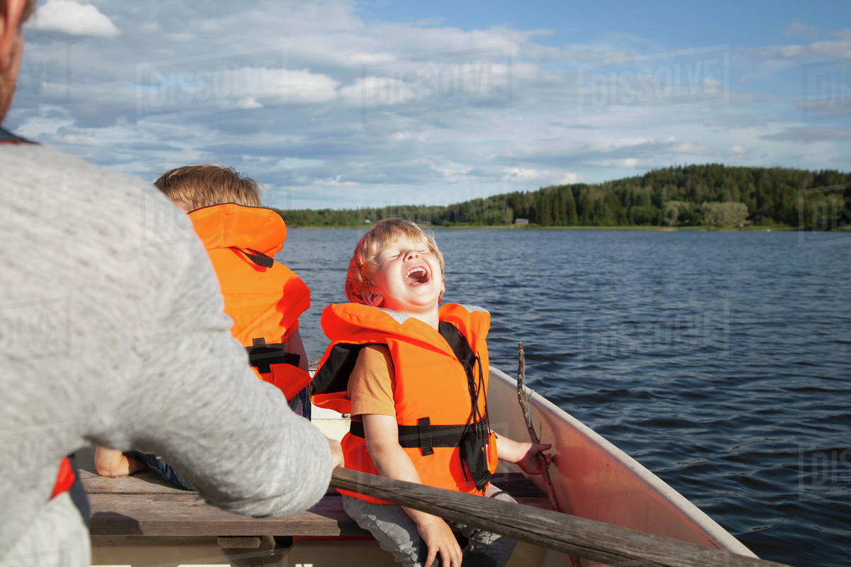 Adult sailing with excited boys on boat in lake, Finland - Stock Photo ...