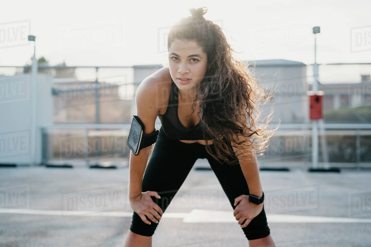 Young woman bending forward and resting on rooftop deck - Royalty-free ...